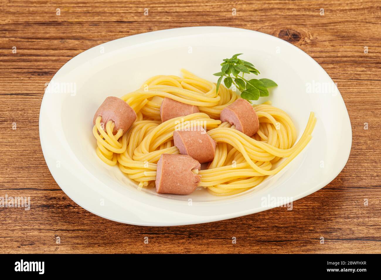 Kids pasta spaghetti with sausages and basil Stock Photo - Alamy
