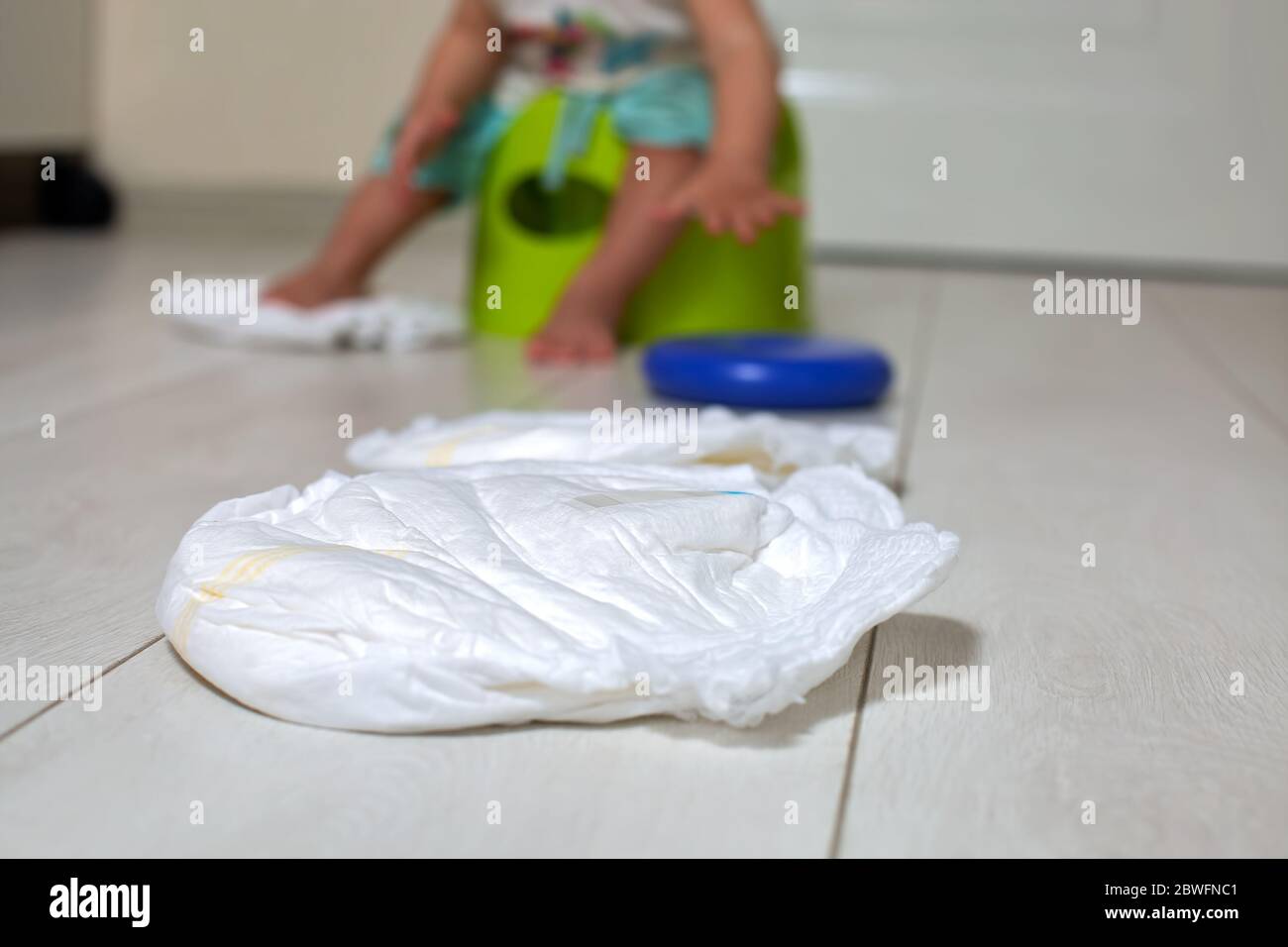potty training concept. close-up a diaper lies on a white floor, in the ...