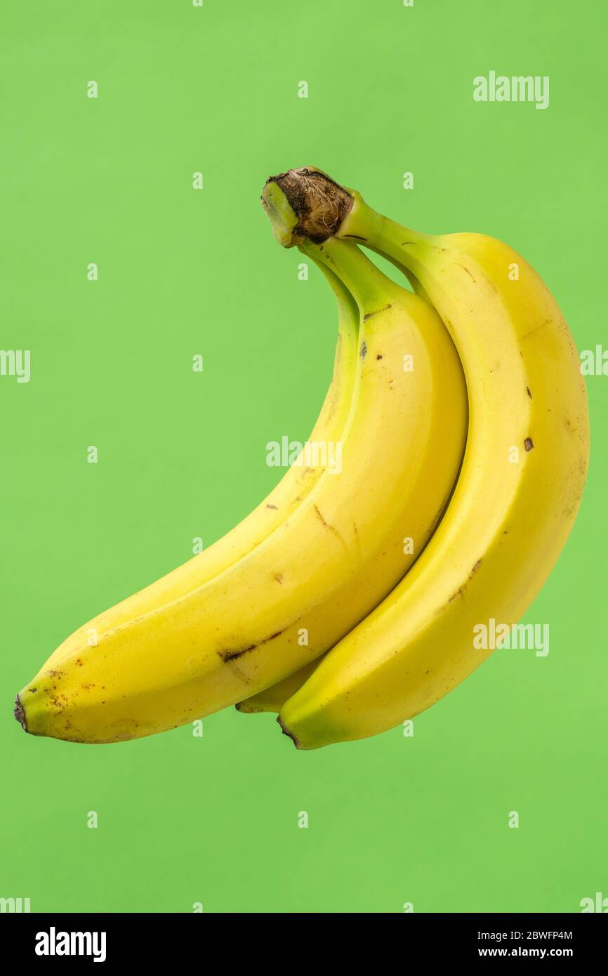 Bunch of fresh bananas isolated on green background Stock Photo - Alamy
