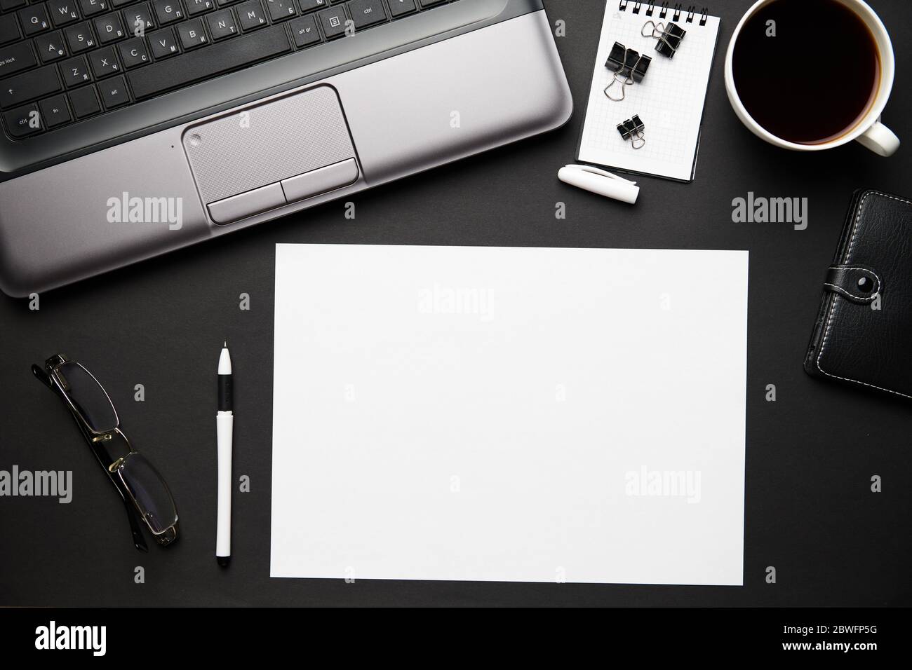 Top view of modern black office desk with laptop, notebook, pencil and ...
