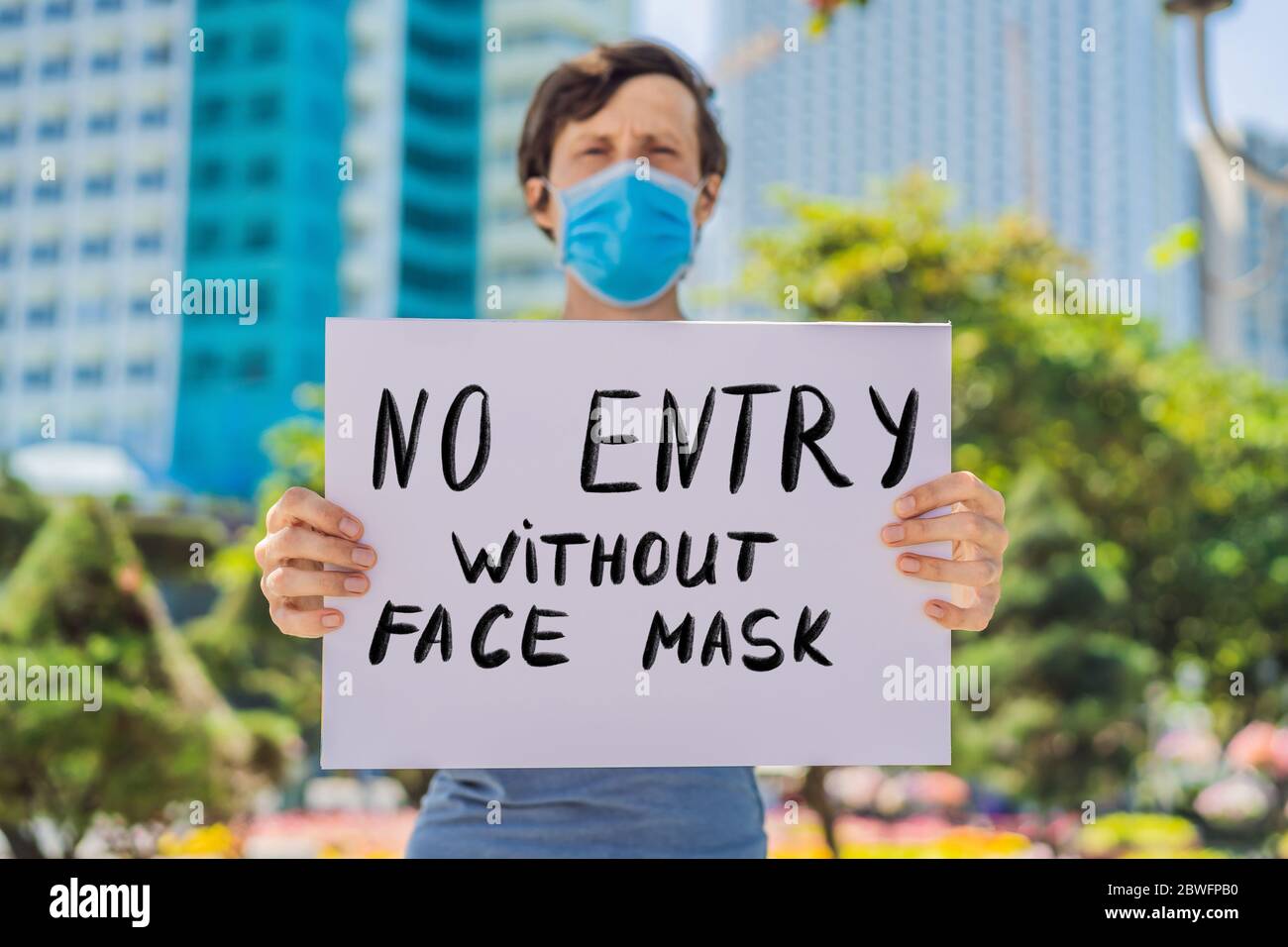 Man in medical mask prevents coronavirus disease holds a poster no ...