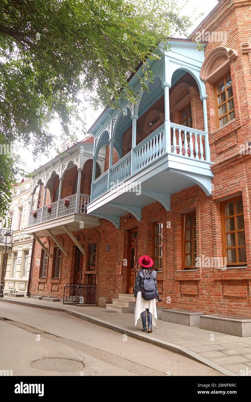 Woman Walking along a Narrow Street with Georgian Traditional Buildings ...