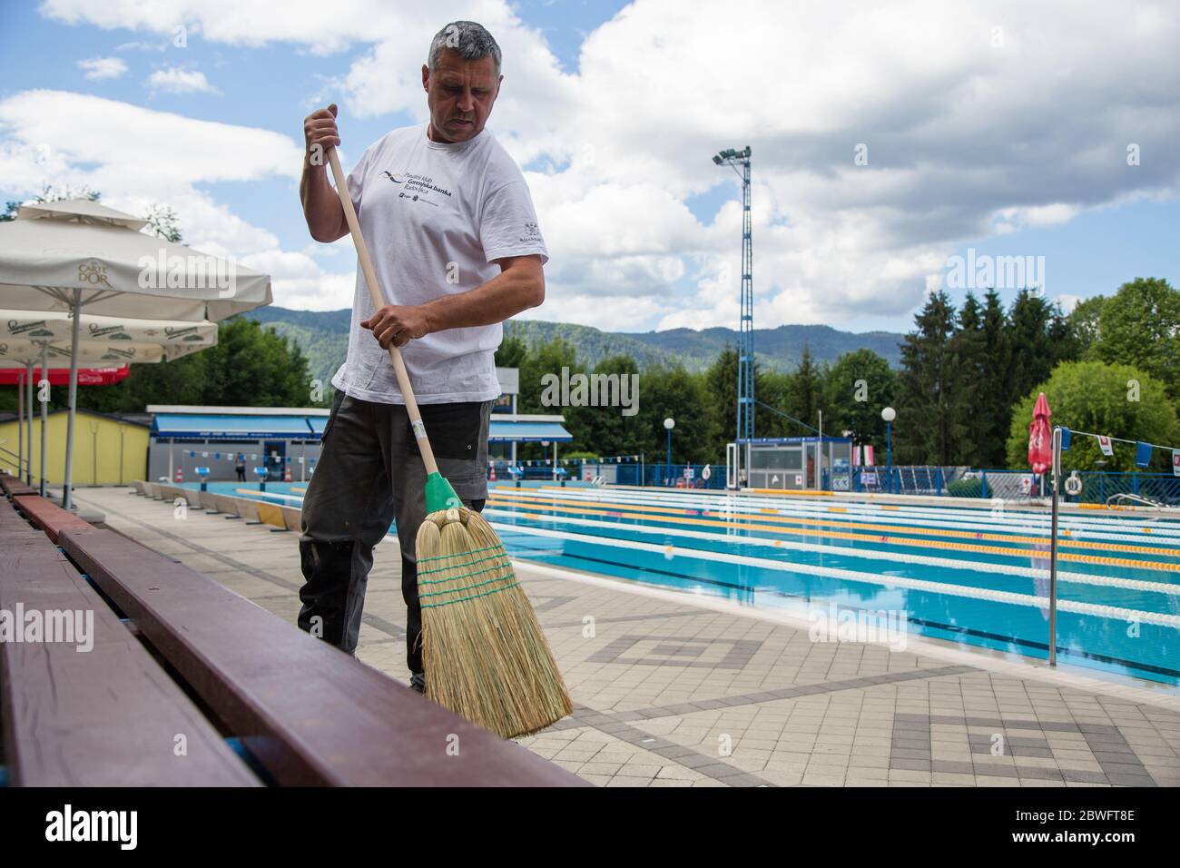Pool staff cleans the swimming pool area as water parks reopen.Swimming ...