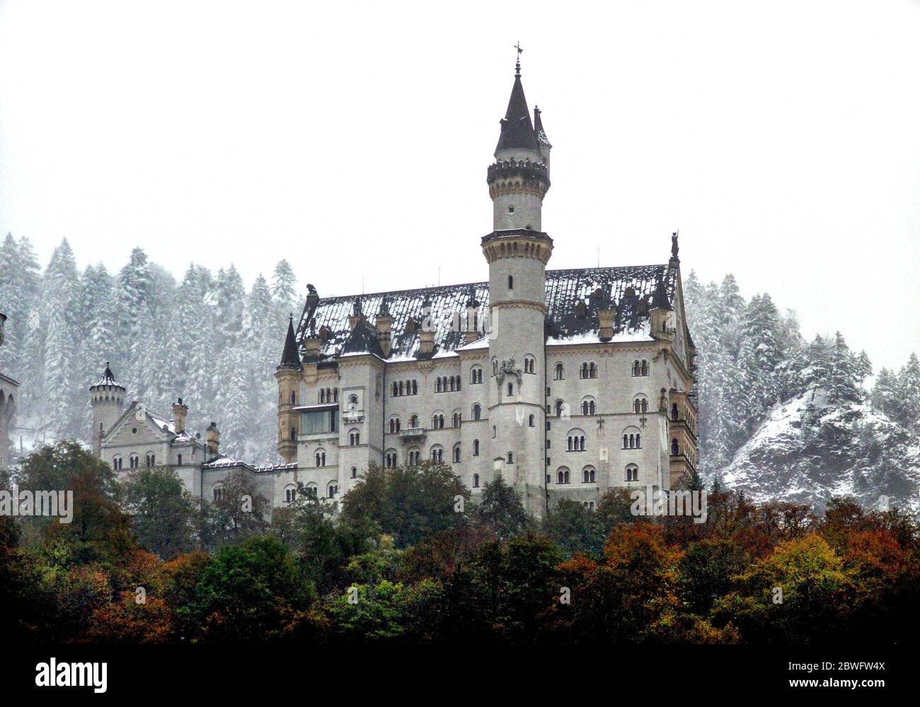 Snow covers the mountain trees and rooftops at Neuschwanstein Castle ...