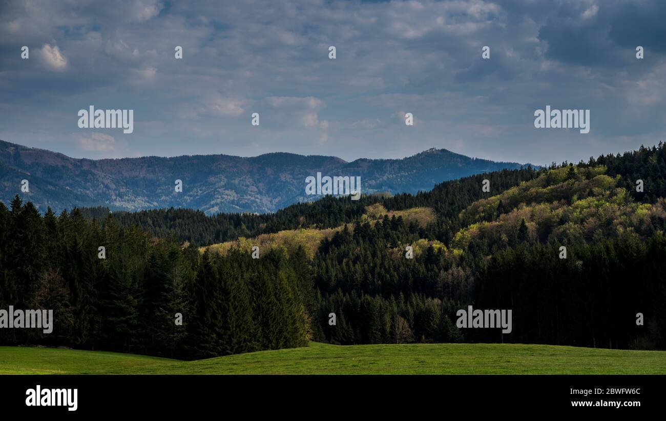 Germany, Dark atmosphere and dramatic sky over green meadow in black ...