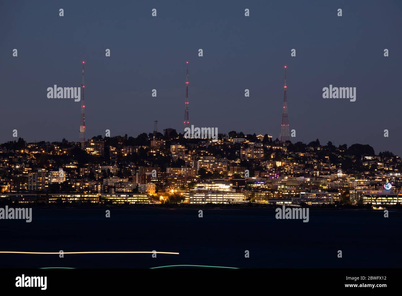 Illuminated waterfront city buildings at night with three ...