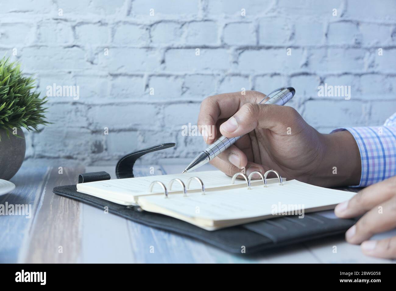 person hand writing on notepad at office desk Stock Photo - Alamy