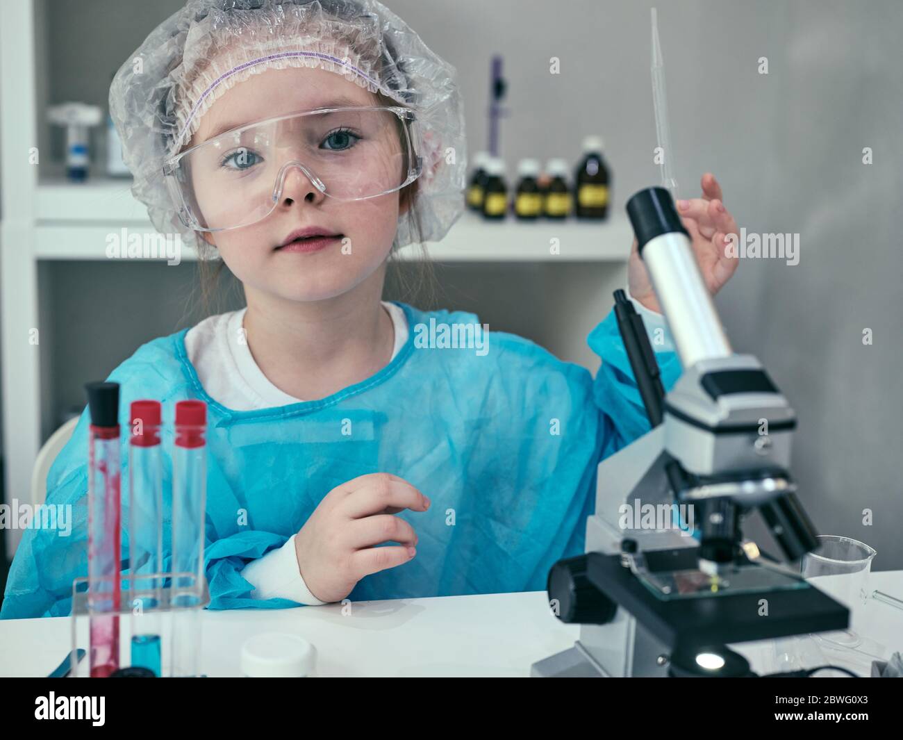 Little adorable girl makes scientific experiments with chemical and ...