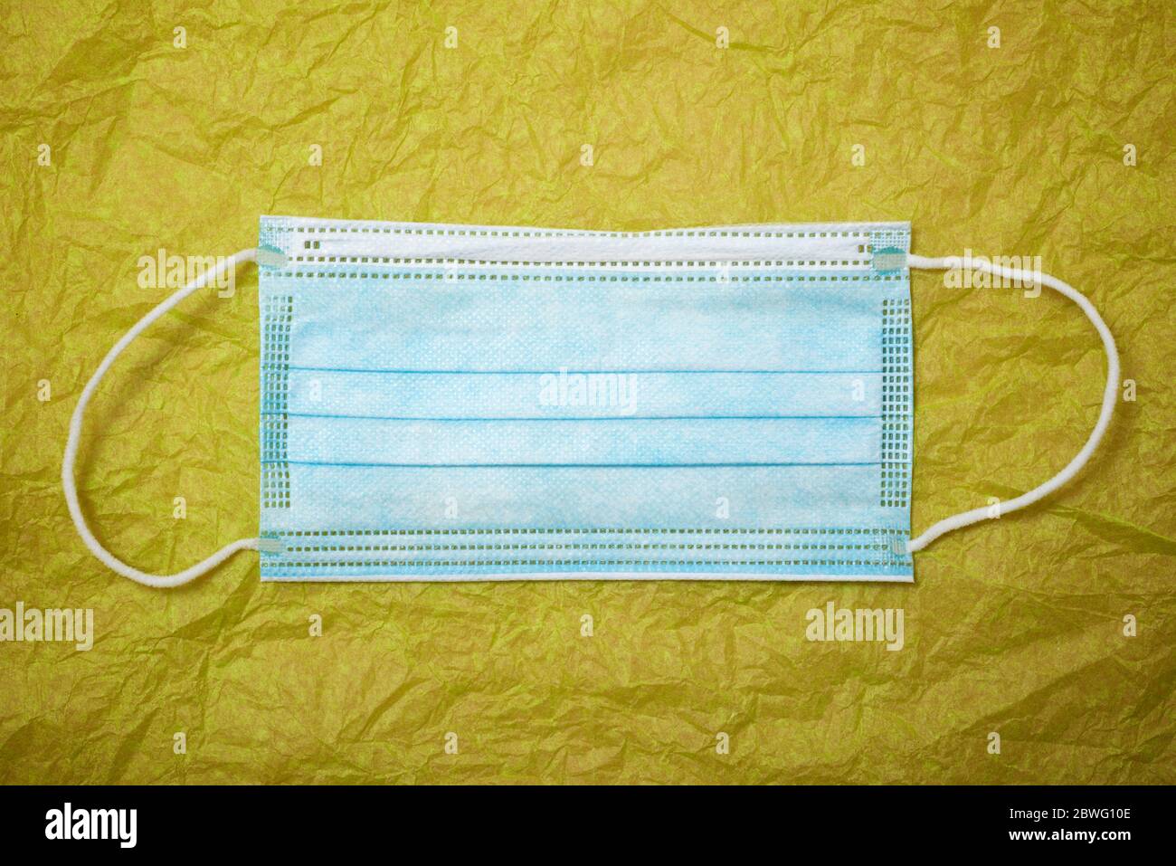 Surgical mask on a yellow surface Stock Photo - Alamy