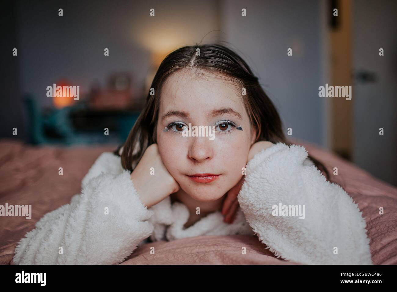 portrait of tween girl laying on her bed looking at camera Stock Photo ...