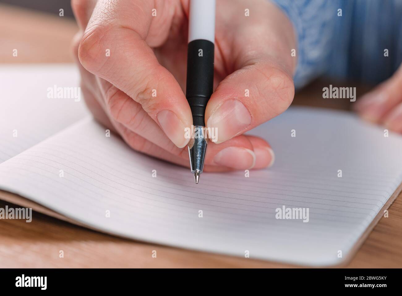 Beautiful Female hands write pen in a notebook of tasks and goals to ...