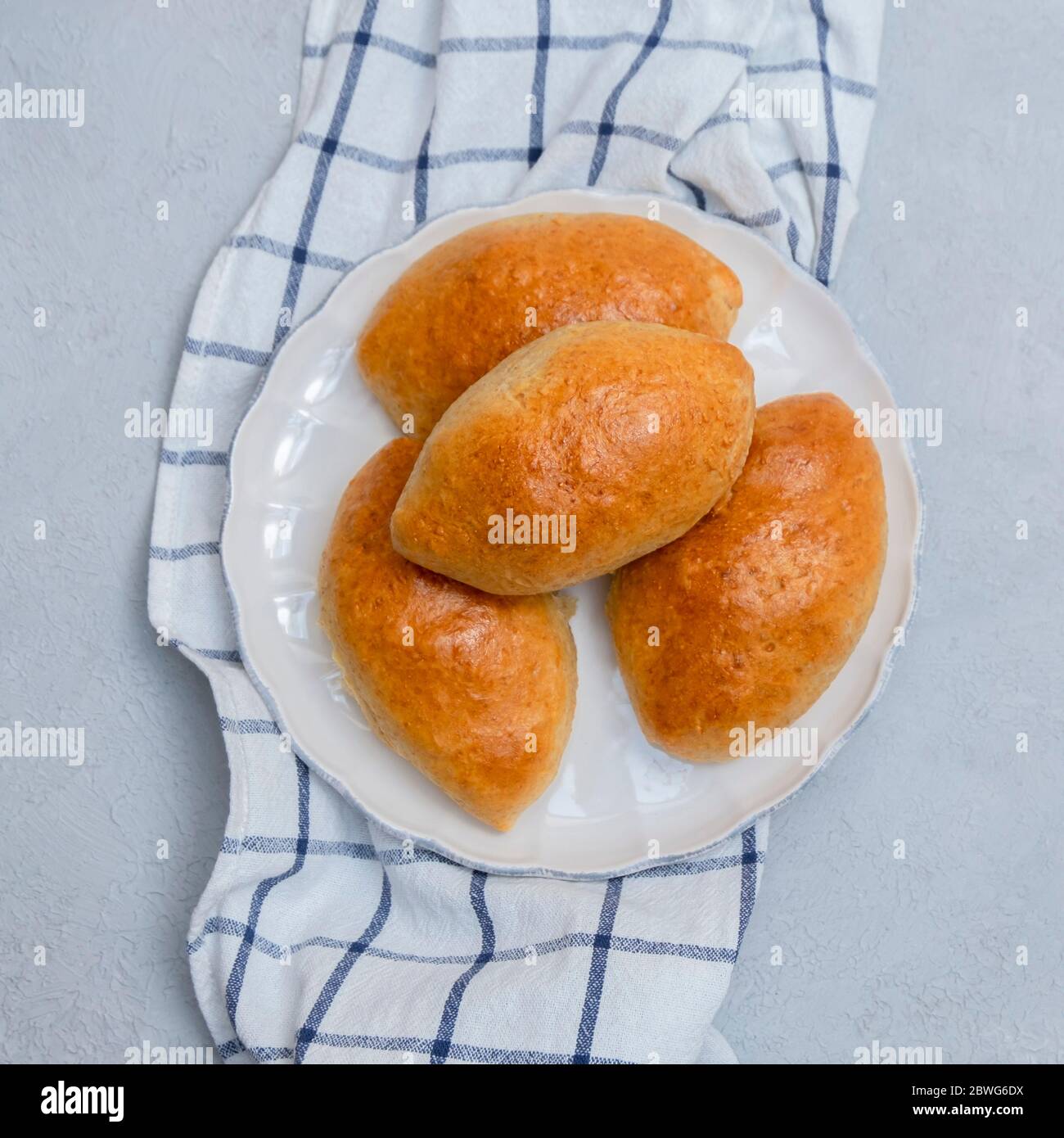 Traditional russian stuffed buns (Piroshki) on white plate on concrete ...