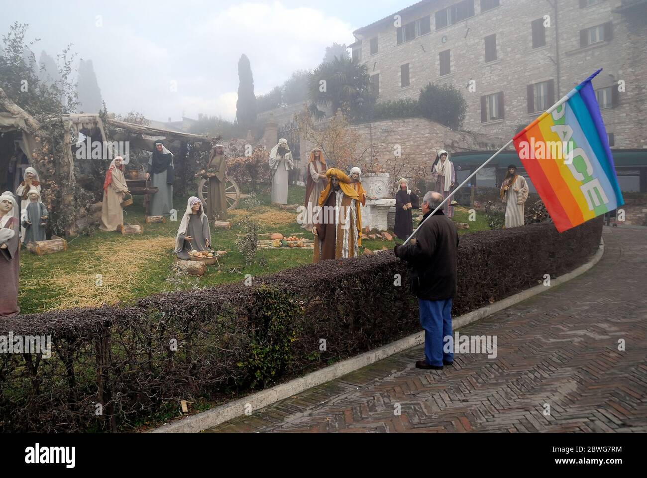 Assisi, a man with a peace flag loooks at the Nativity scene Stock ...