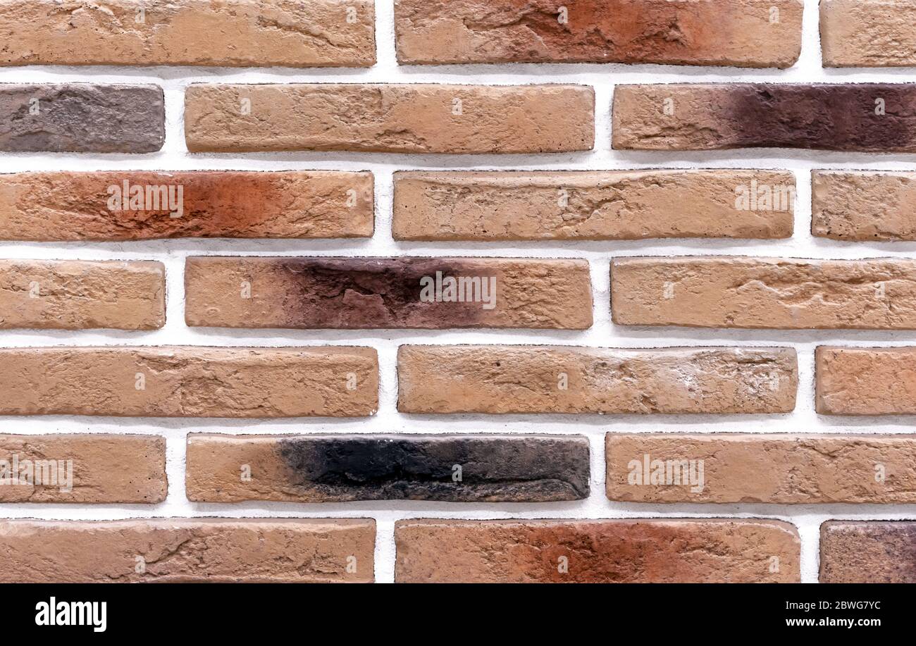 Brick wall of beige and brown bricks. Background and texture of ...
