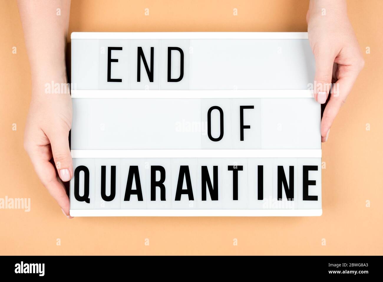Lightbox with the text End of quarantine on a beige background in women ...