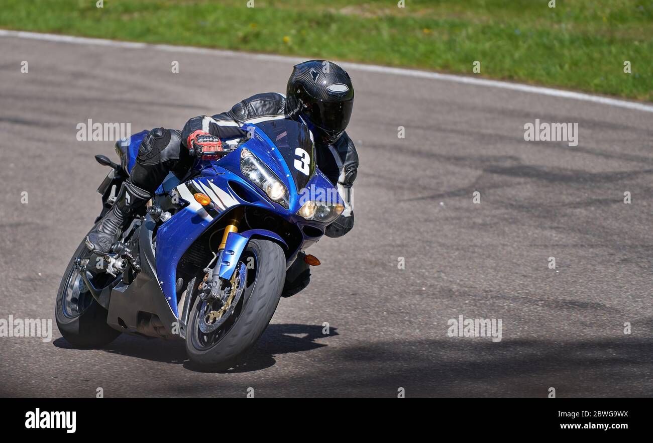 Motorcycle practice leaning into a fast corner on track Stock Photo - Alamy