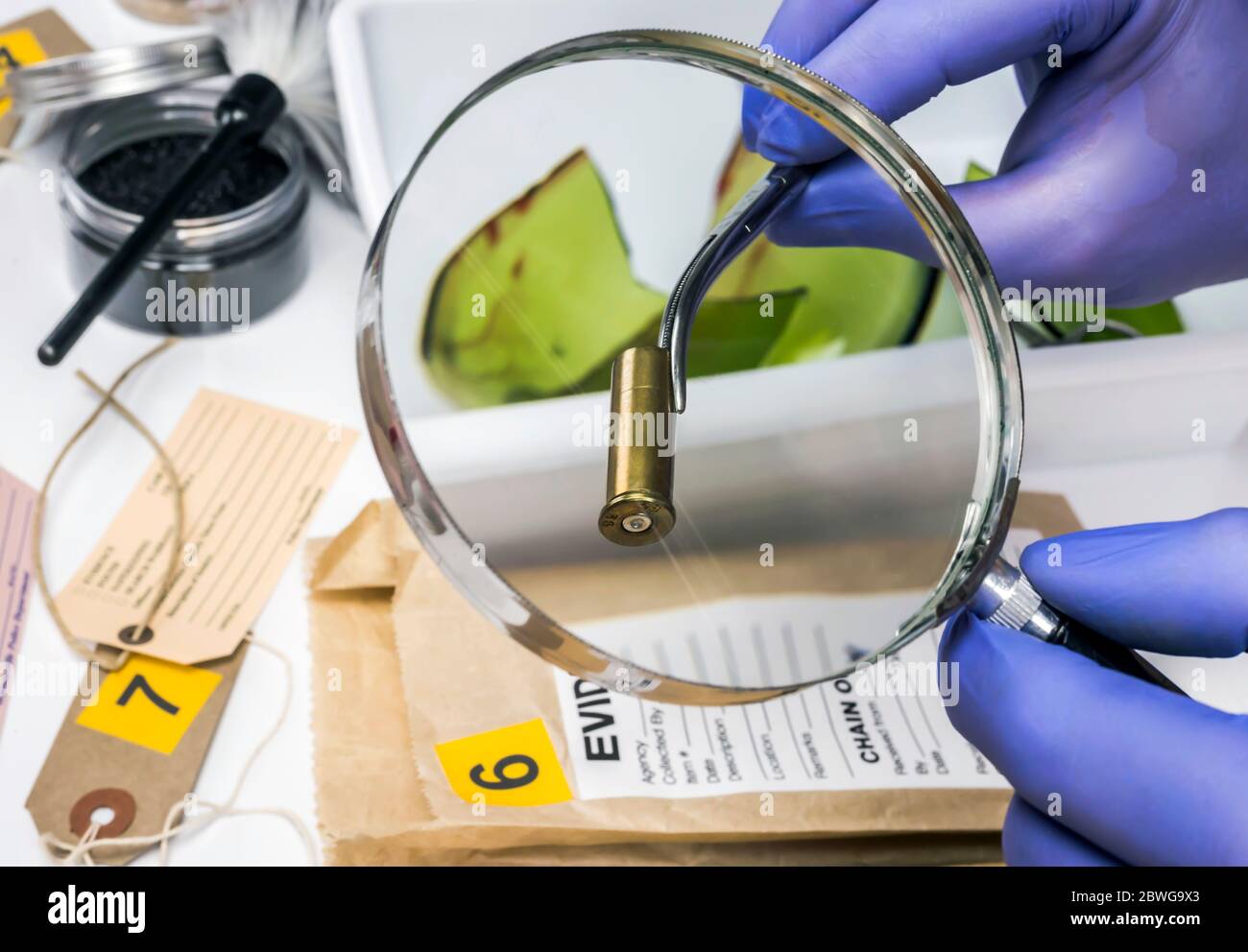 Expert police examines a bullet cap in scientific laboratory with ...
