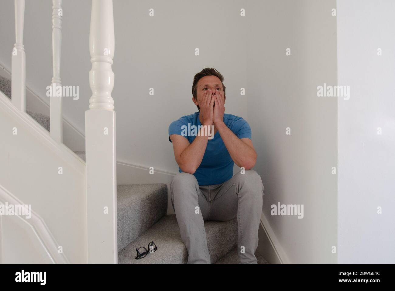 Man struggling with depression sitting on stairs Stock Photo - Alamy