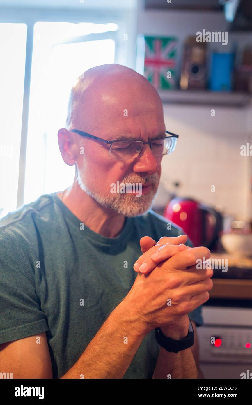 Man in his 50s praying, saying grace before eating at the table Stock ...