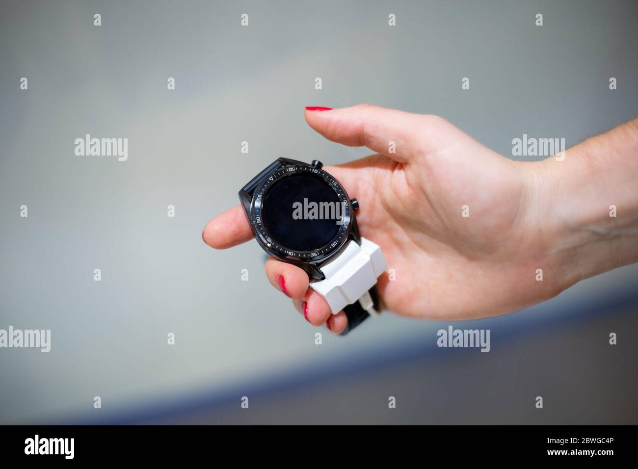 female hand holds new smart watch with empty black screen. copy space ...