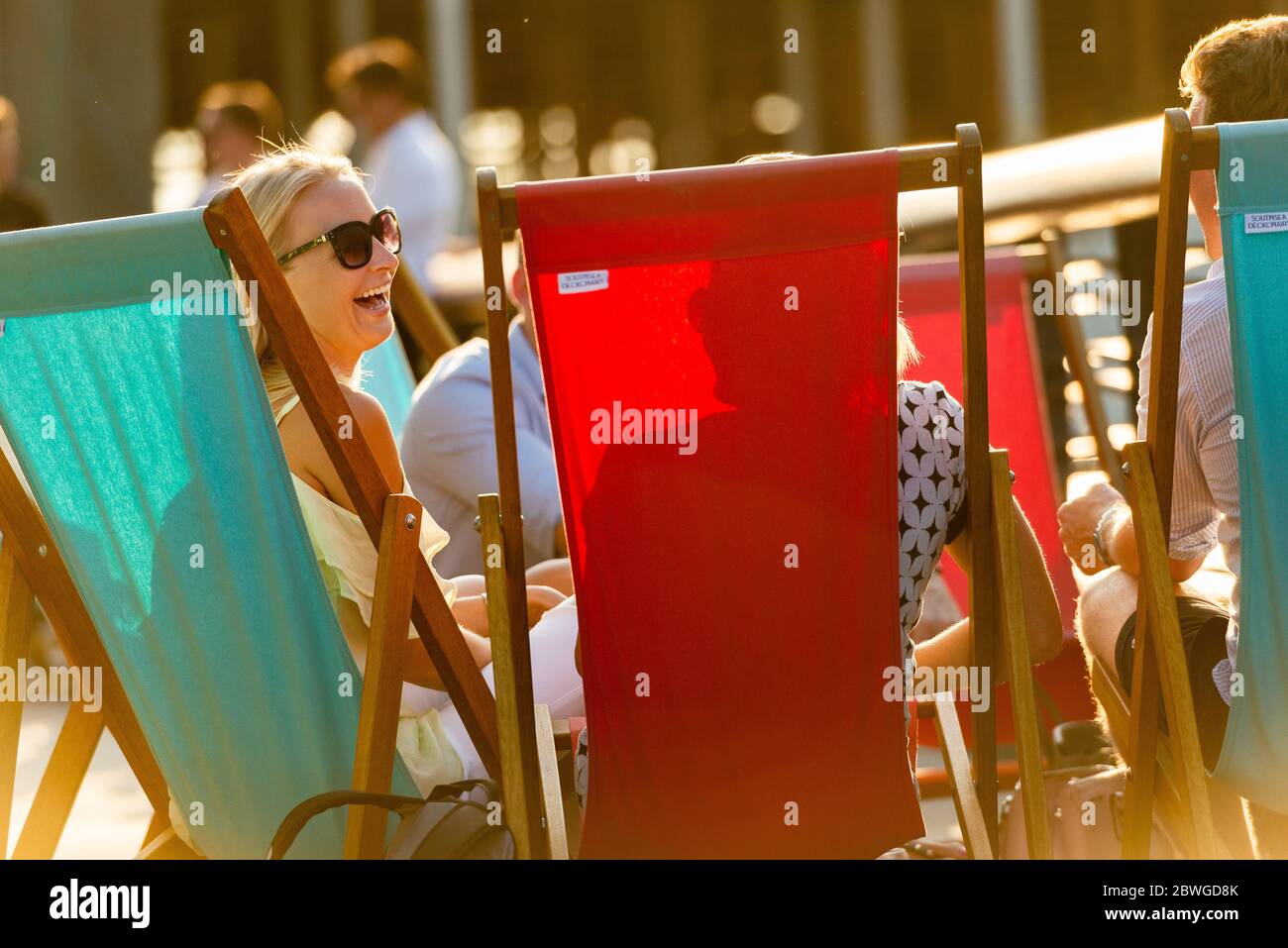 Young people drinking and socialising on a sunny summer evening near ...