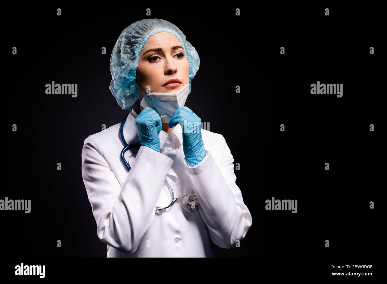 Photo of tired lady doc taking off protective mask after late operation ...