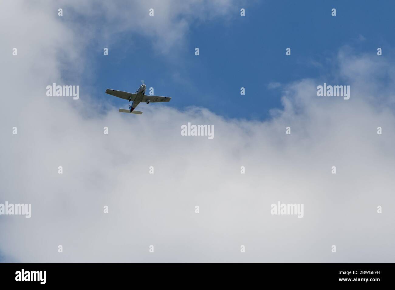 a small white plane flies in the sky Stock Photo - Alamy