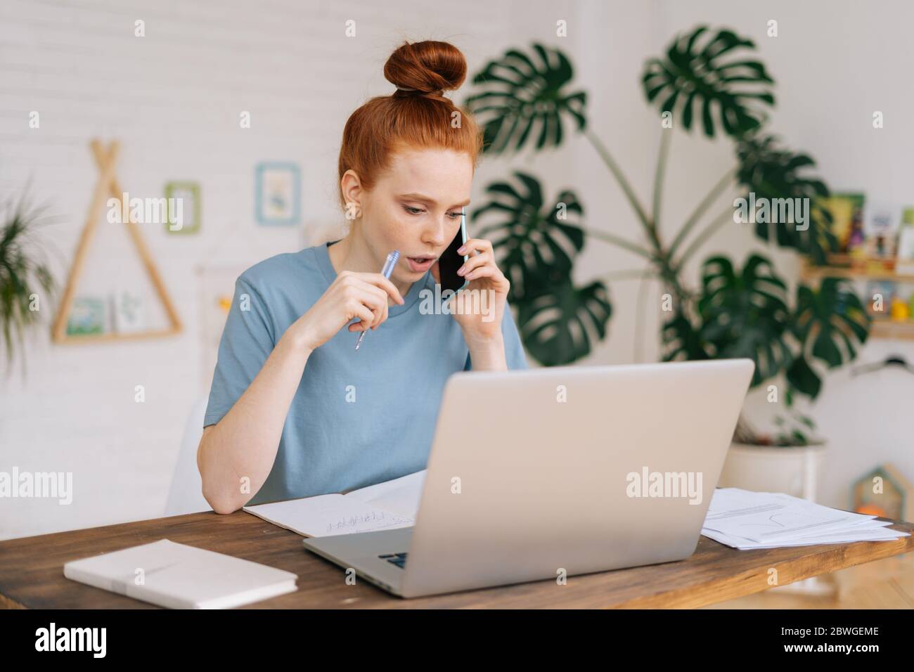 Concentrated serious redhead young woman accountant is communicating ...