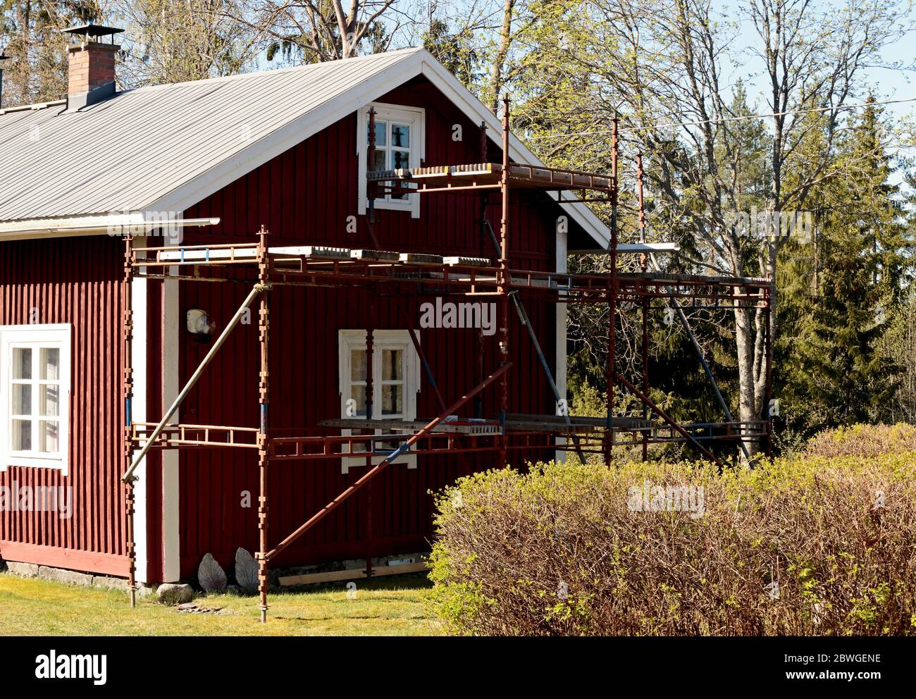 A red wooden house under renovation with rack Stock Photo - Alamy