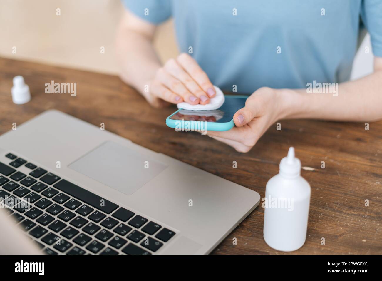 Close-up of hands of unrecognizable woman cleaning mobile phone with ...