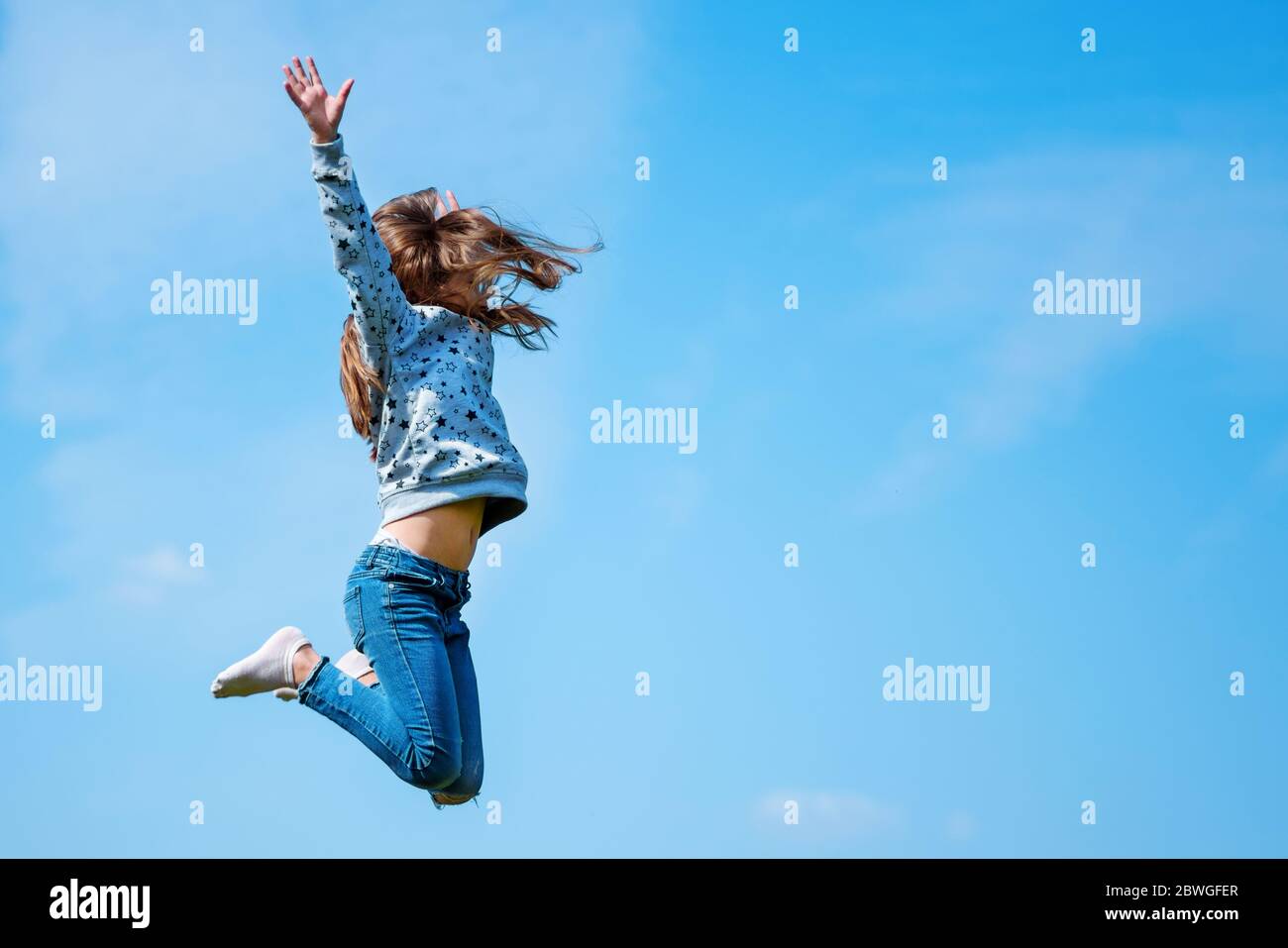 Little girl jumping against beautiful sky.Little girl jumping against ...