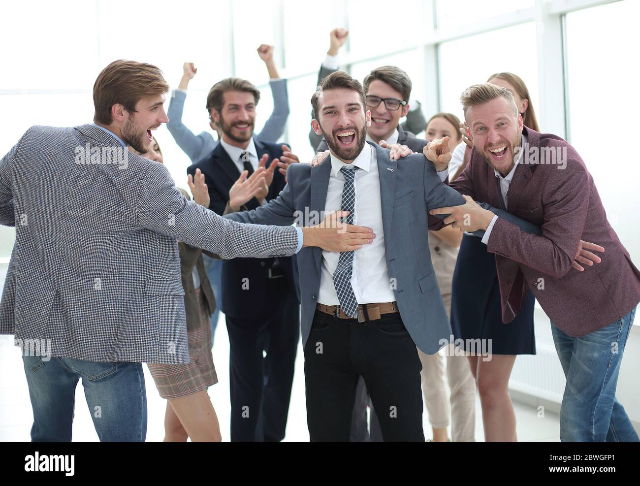 jubilant group of employees congratulating their leader on the victory ...