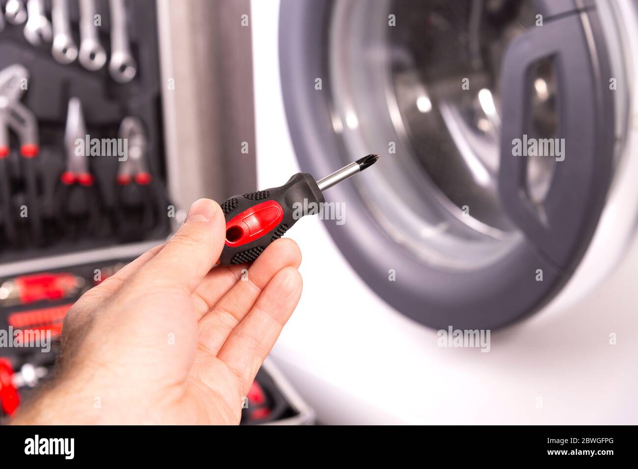 Repair and maintenance of the washing machine. Screwdriver in the hand ...