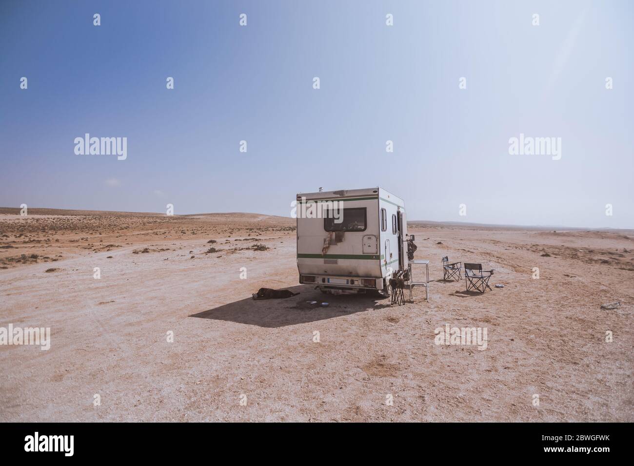 Old rusty camper van in the sandy desert field. Camping site in the ...