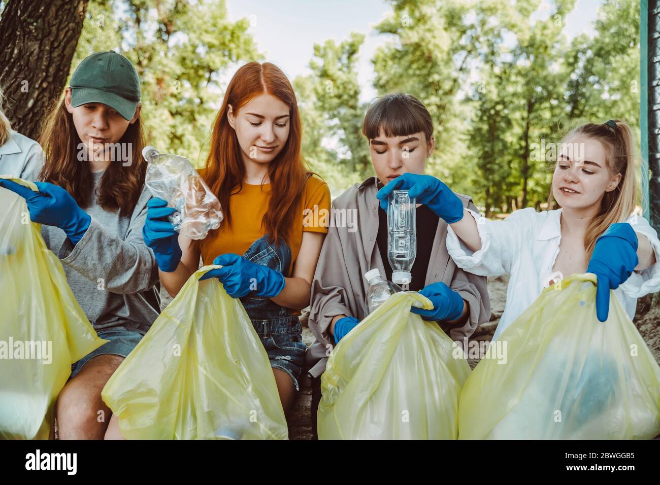 Group of activists friends collecting plastic waste at the park ...