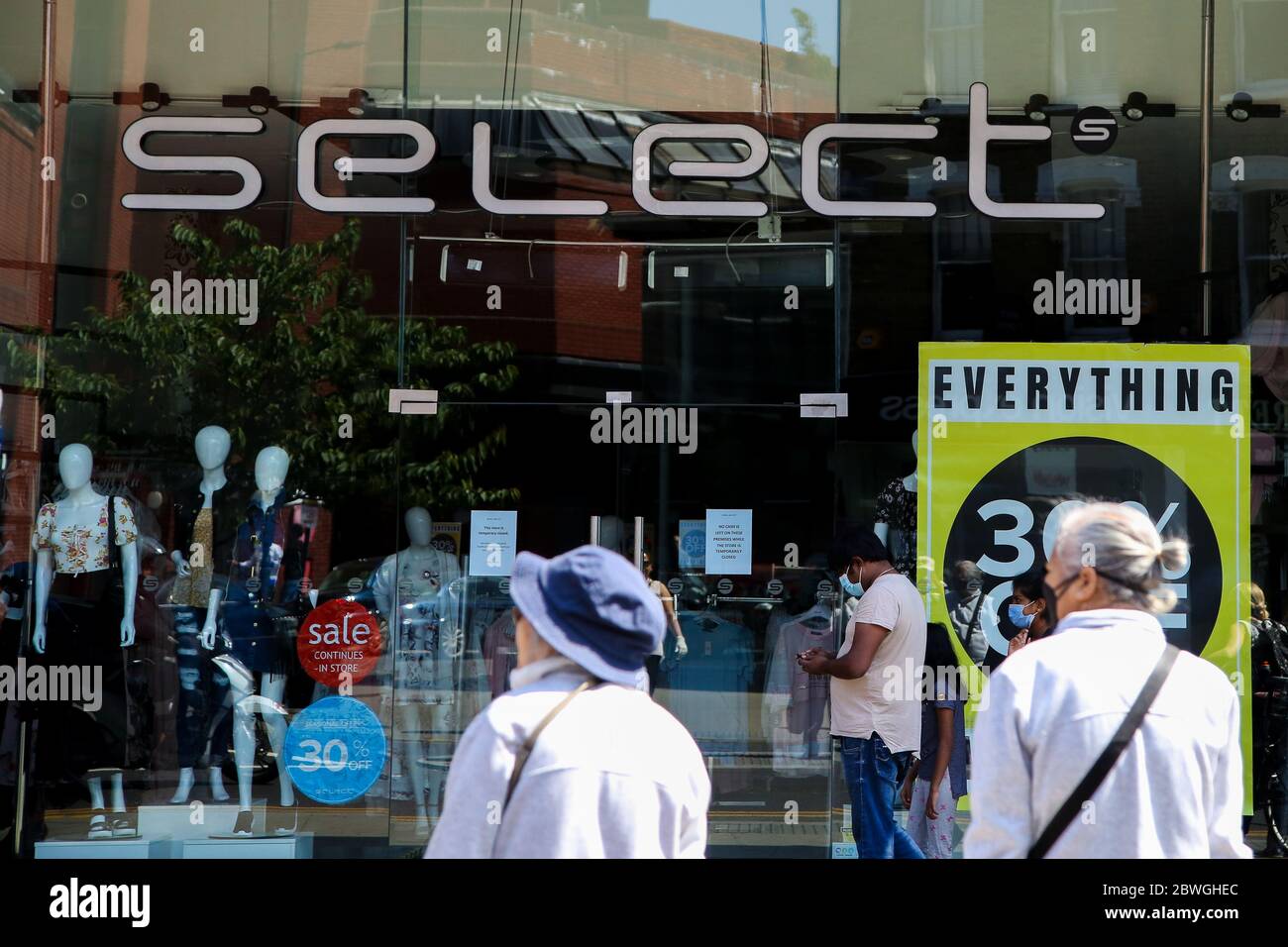 Shoppers are seen outside a branch of Select store in north London ...