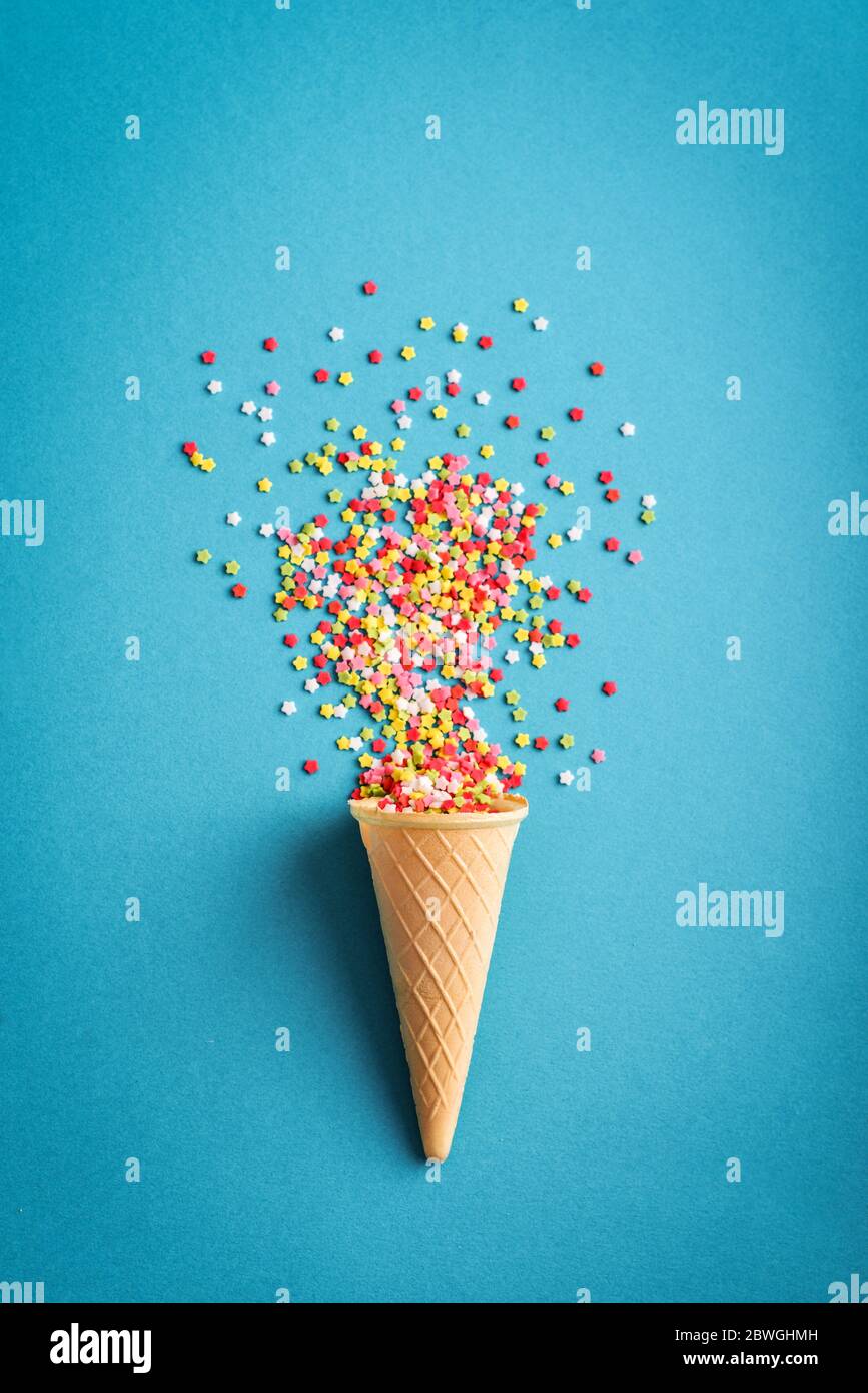 Celebration concept. Ice cream cone with colorful stars confetti on a ...