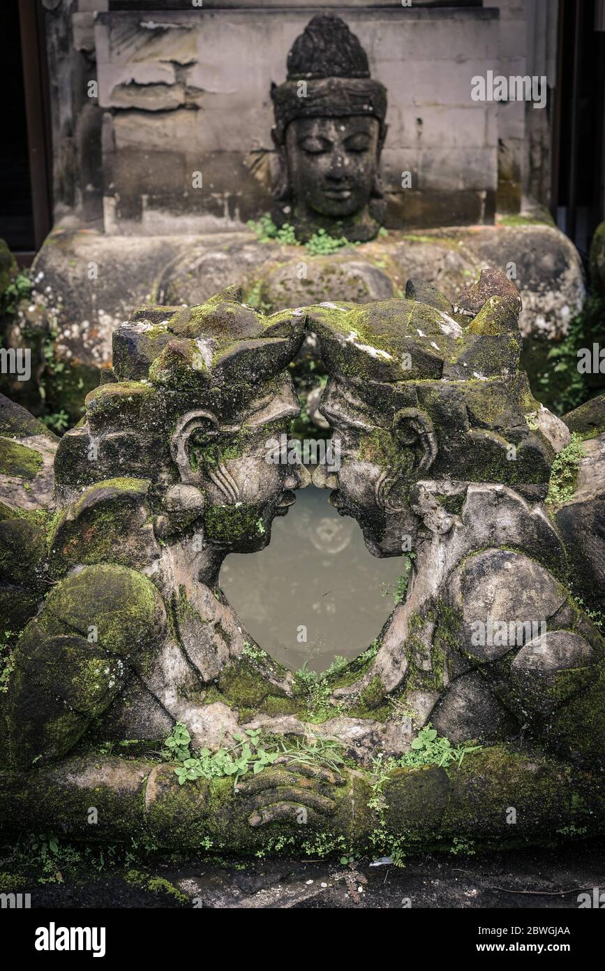 Traditional balinese stone sculpture of a man and woman with moss in ...