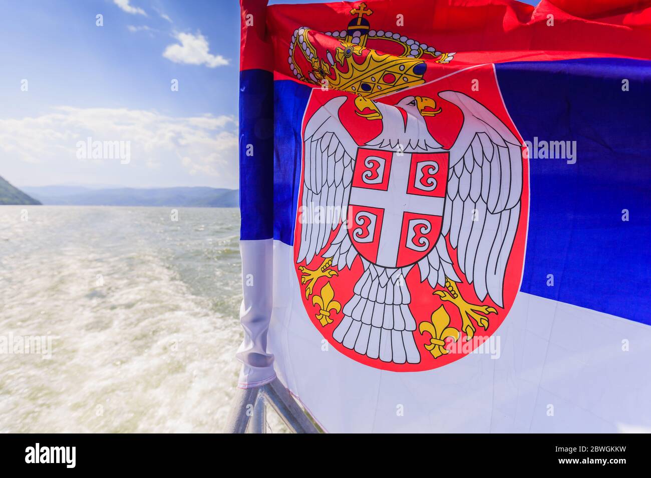 Serbia national flag on tourist boat , Danube river landscape and sky ...
