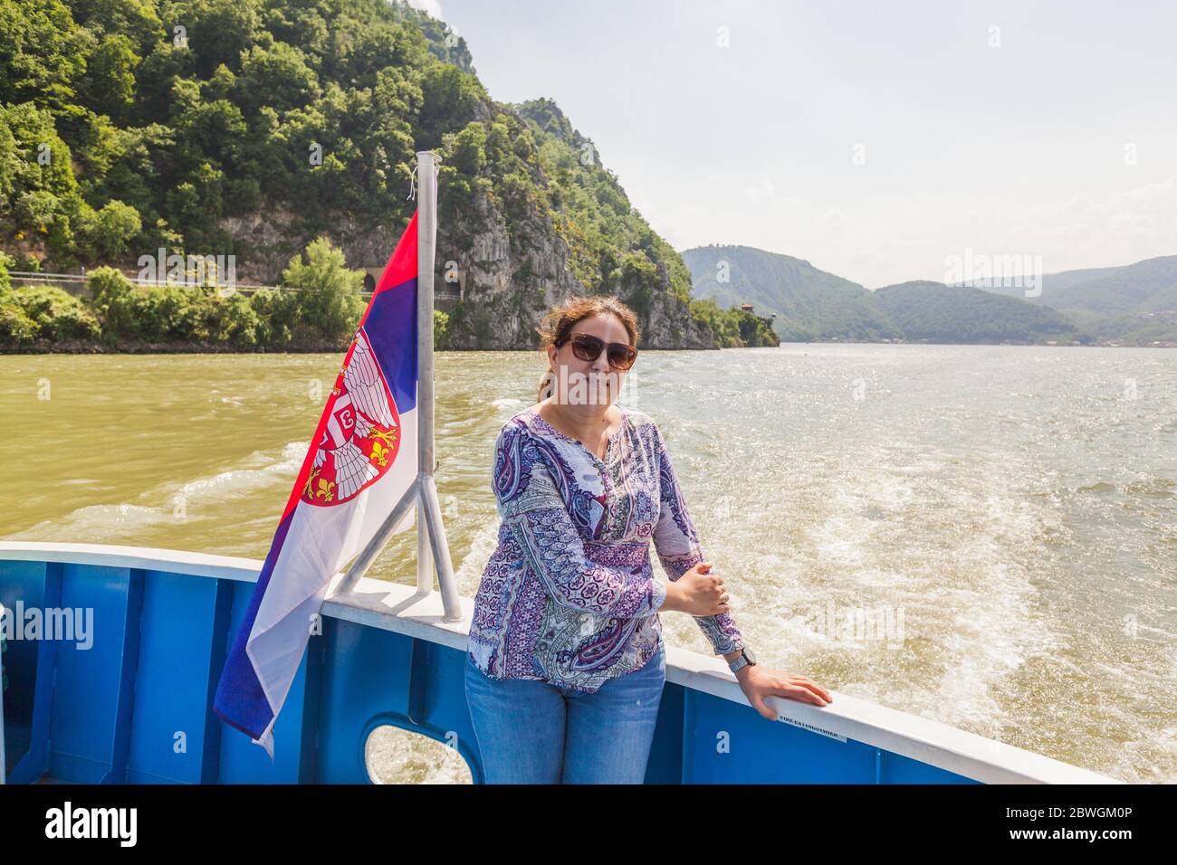 Woman on river cruise with Serbian national flag enjoy view of Danube ...