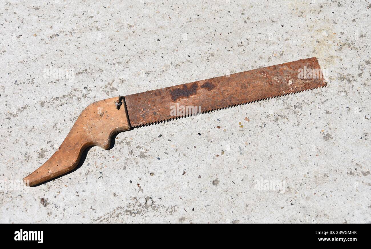 Old and rusty hand saw with wooden handle Stock Photo - Alamy