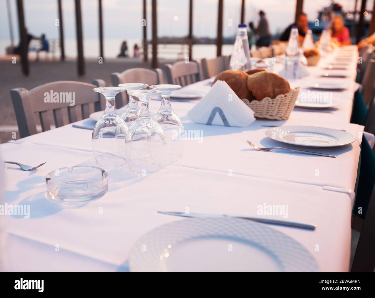 Restaurant table setting for dinner on the beach at beautiful sunset ...