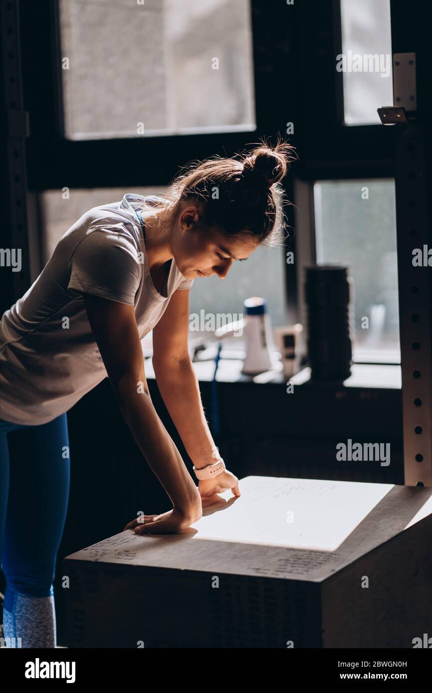 Beautiful woman leaned over the table against window Stock Photo - Alamy