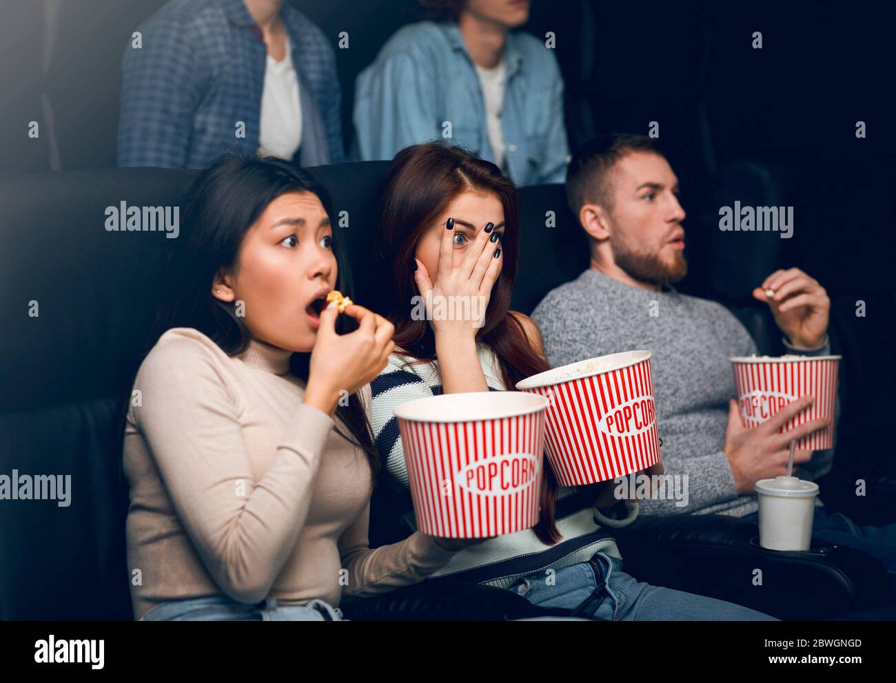 Young people scared of horror movie in film theater Stock Photo - Alamy