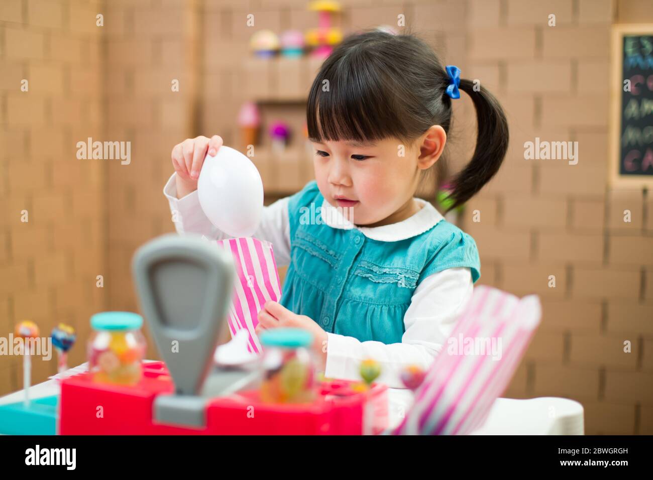 toddler girl pretend play sweet shop keeper at home Stock Photo - Alamy