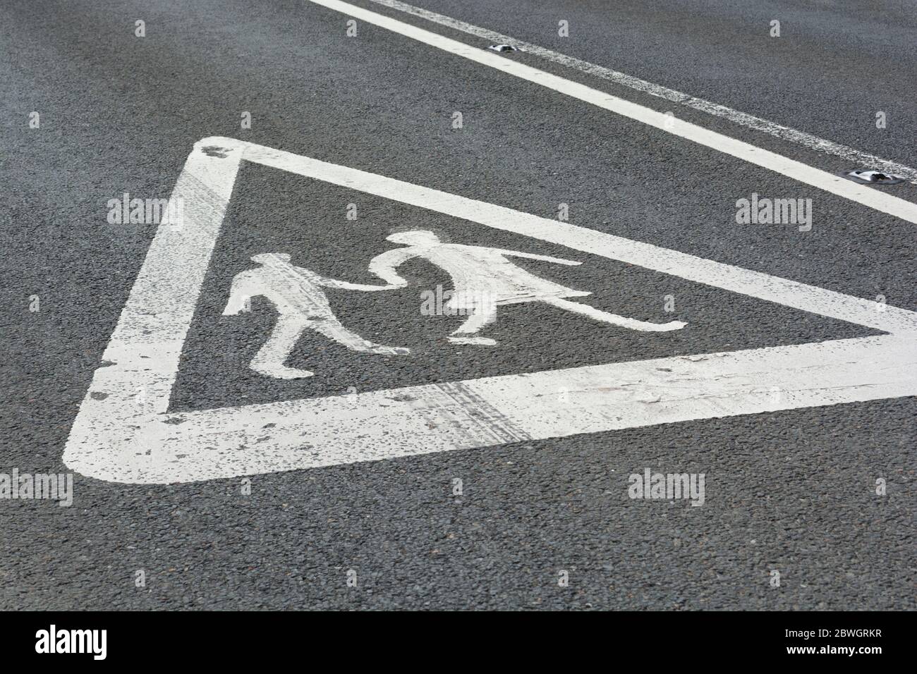 School warning sign on road showing pictogram of girl and boy walking ...