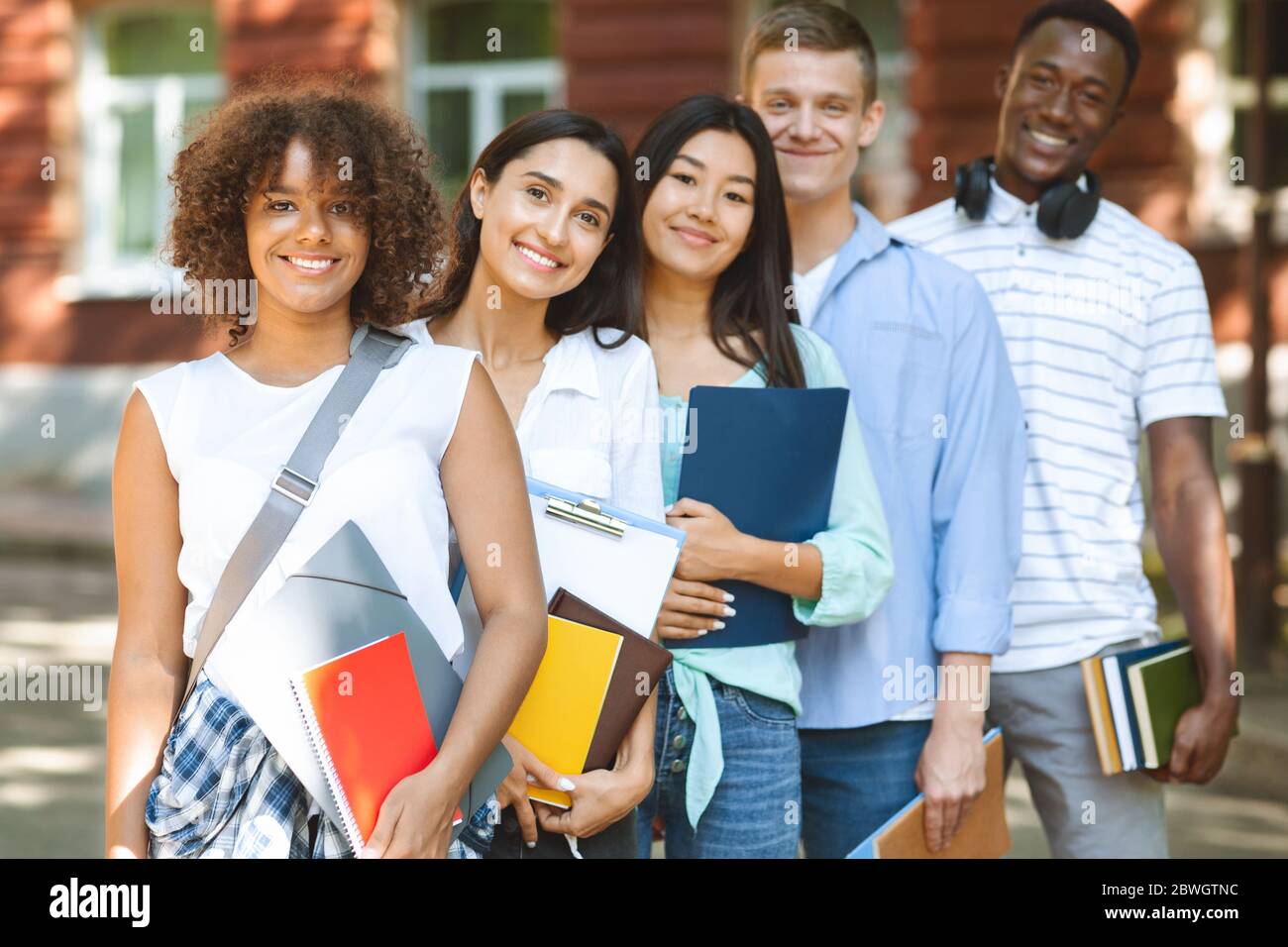 Group of international students posing near college building, smiling ...