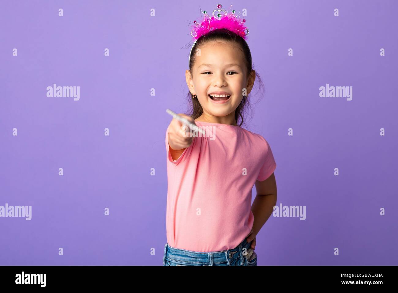 Asian girl wearing princess crown, holding magic wand Stock Photo - Alamy