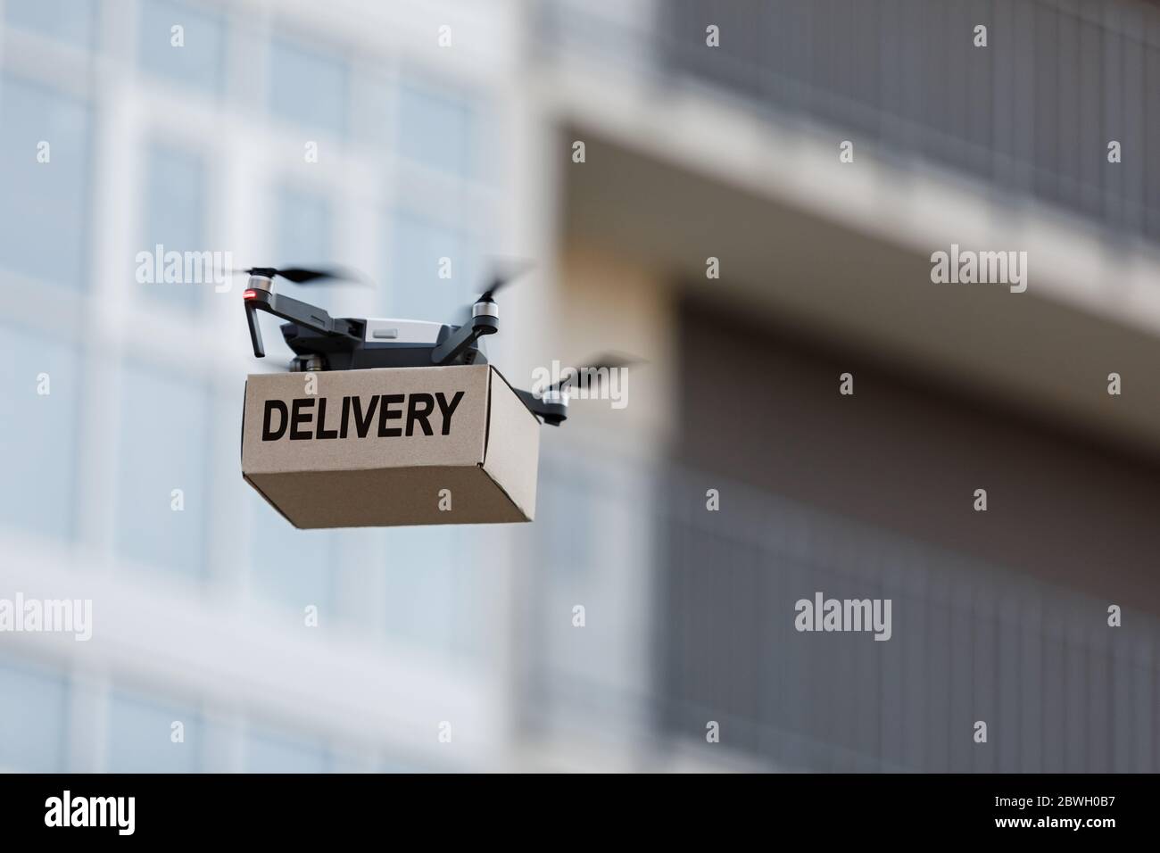 Modern drone delivering packages against city background Stock Photo ...
