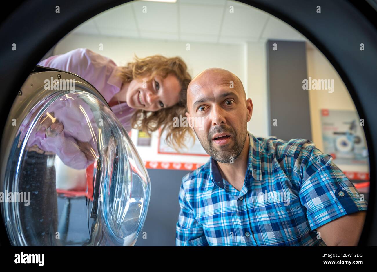 laundry, surprised look men and women into the washing machine or ...